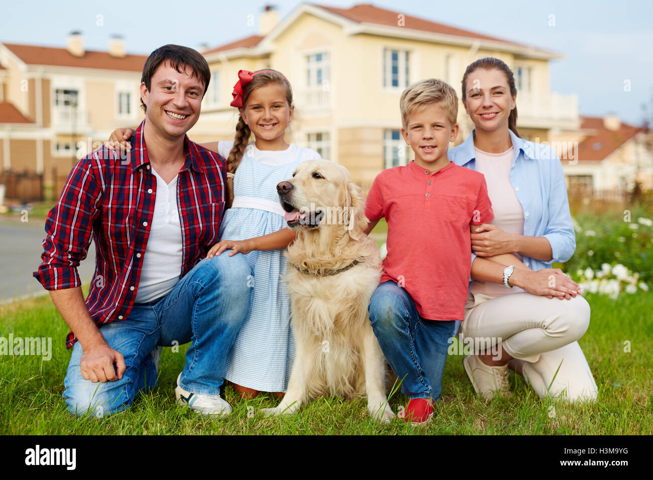 Happy family with dog looking at camera outdoors Stock Photo - Alamy