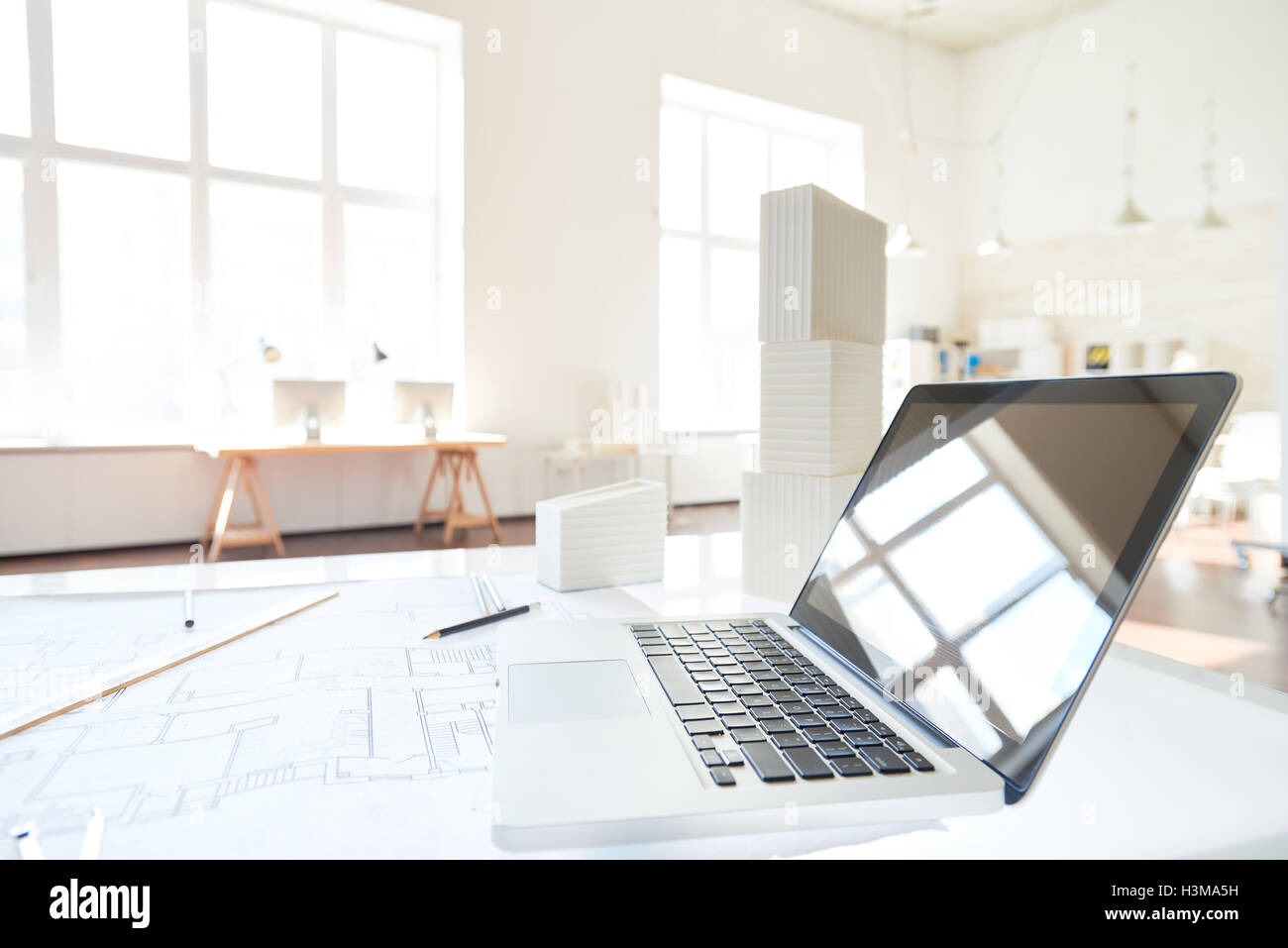 Laptop on engineering sketch at workplace of architect Stock Photo - Alamy