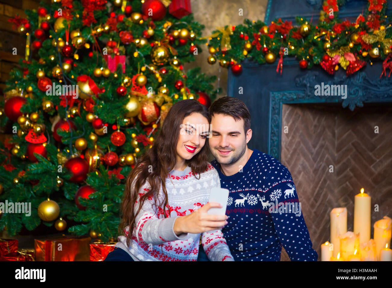 Young couple near fireplace celebrating Christmas. Love and ...