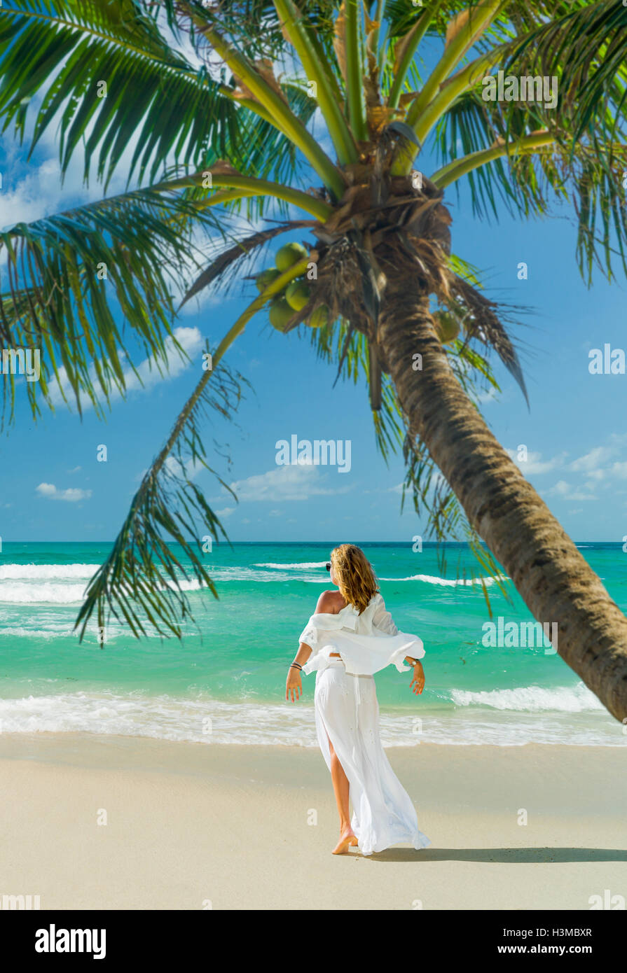 Young woman walking on idyllic tropical beach Stock Photo - Alamy