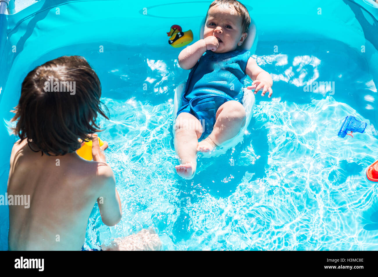 Happy brothers playing in inflatable pool on summer day Stock Photo - Alamy