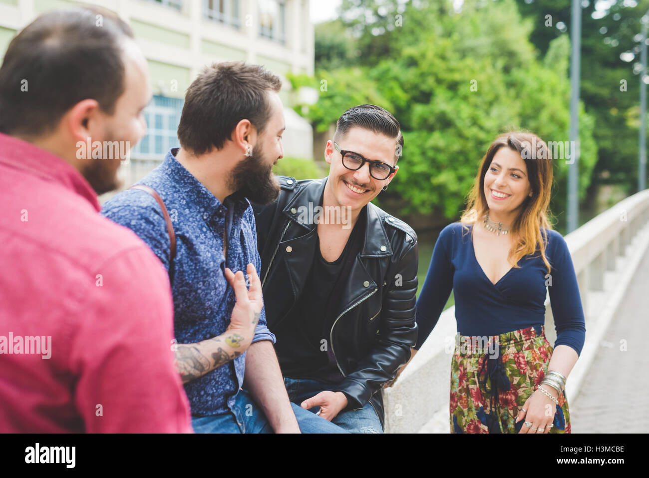 Group of friends chatting by roadside Stock Photo - Alamy