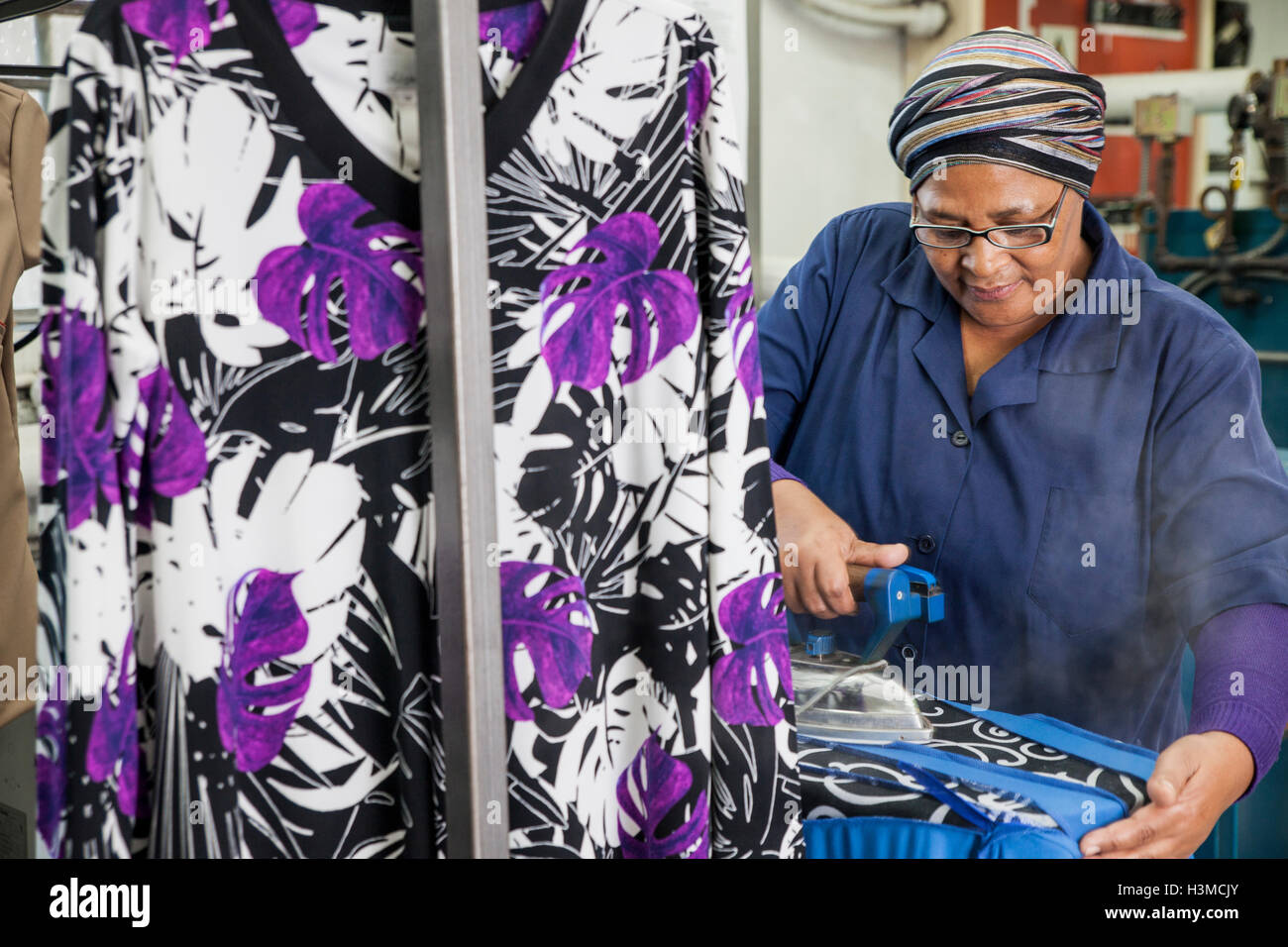 Worker ironing dress in garment factory Stock Photo - Alamy