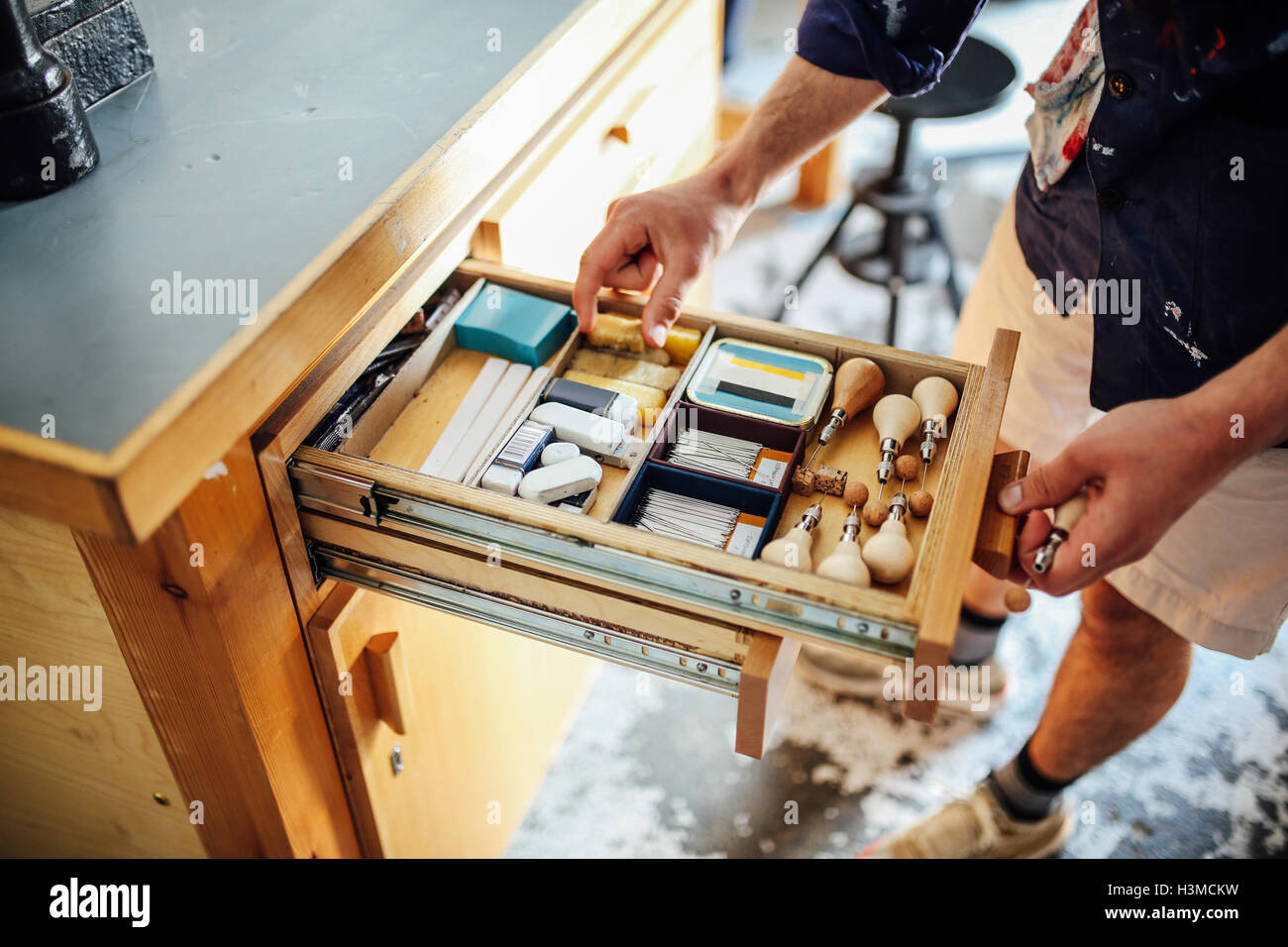 Hand reaching into open drawer containing equipment and materials in ...