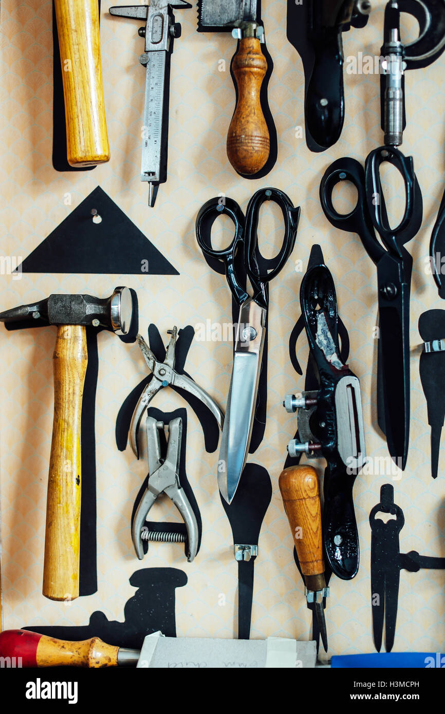 Scissors and tools hanging on wall in arts studio Stock Photo - Alamy