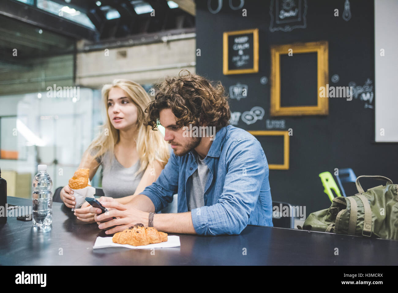 Co-workers having morning break at table Stock Photo - Alamy