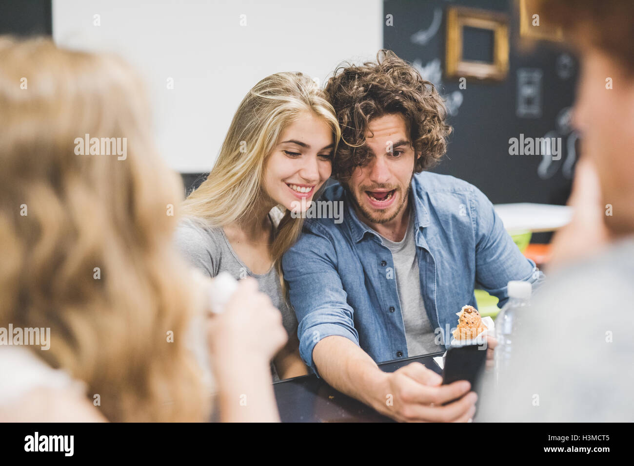 Co-workers having morning break at table Stock Photo - Alamy