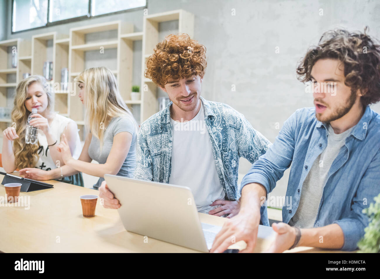 Co-workers working in open plan office Stock Photo - Alamy