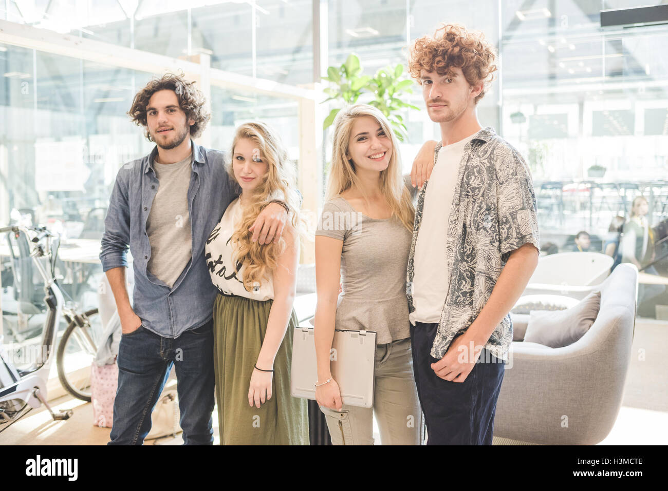 Co-workers standing in open plan office Stock Photo - Alamy
