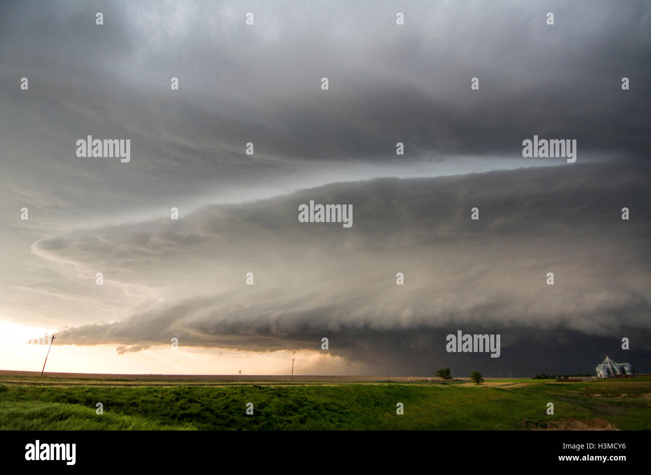 A tornado-producing supercell thunderstorm spinning over ranch land ...