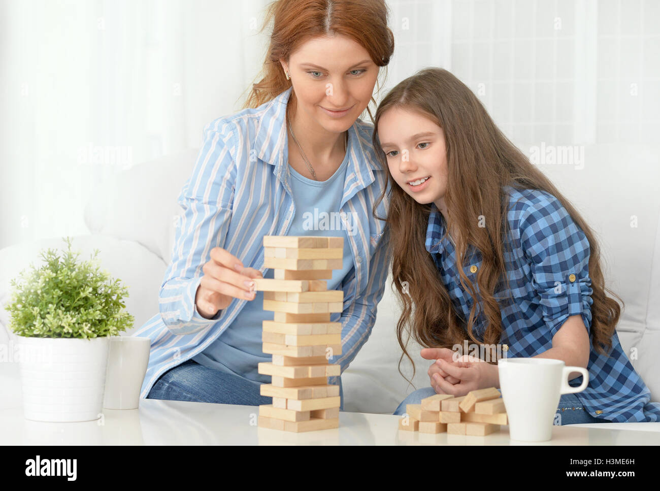 Family at the table playing board game Stock Photo - Alamy