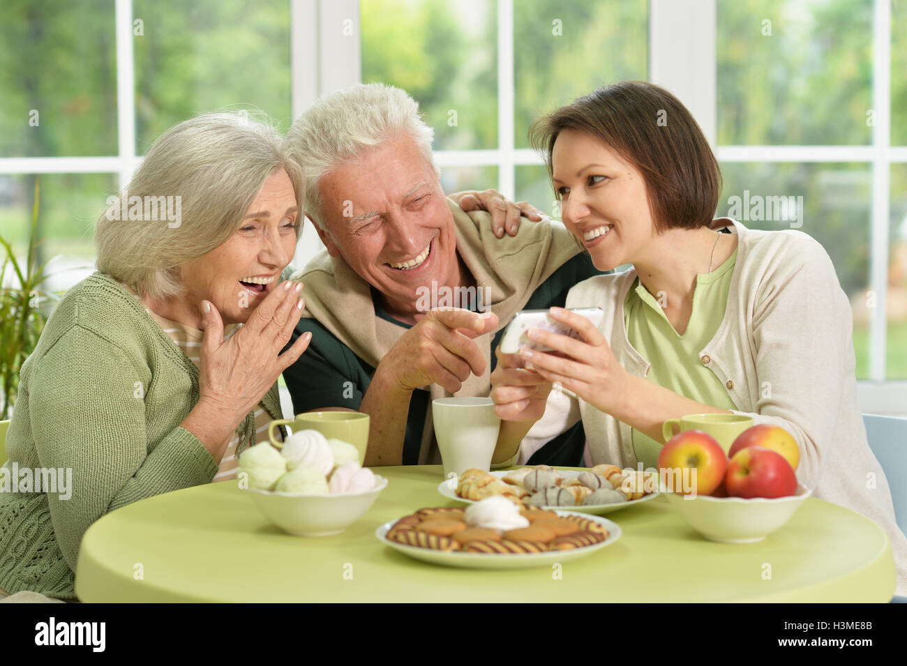 Daughter with senior parents drinking tea Stock Photo - Alamy