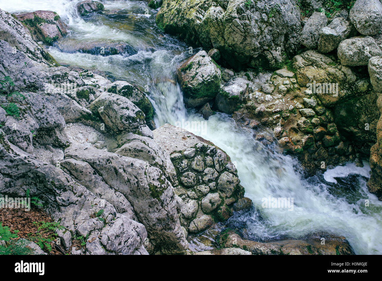 Mountain stream detail, cold freshwater running over rocks and stones ...