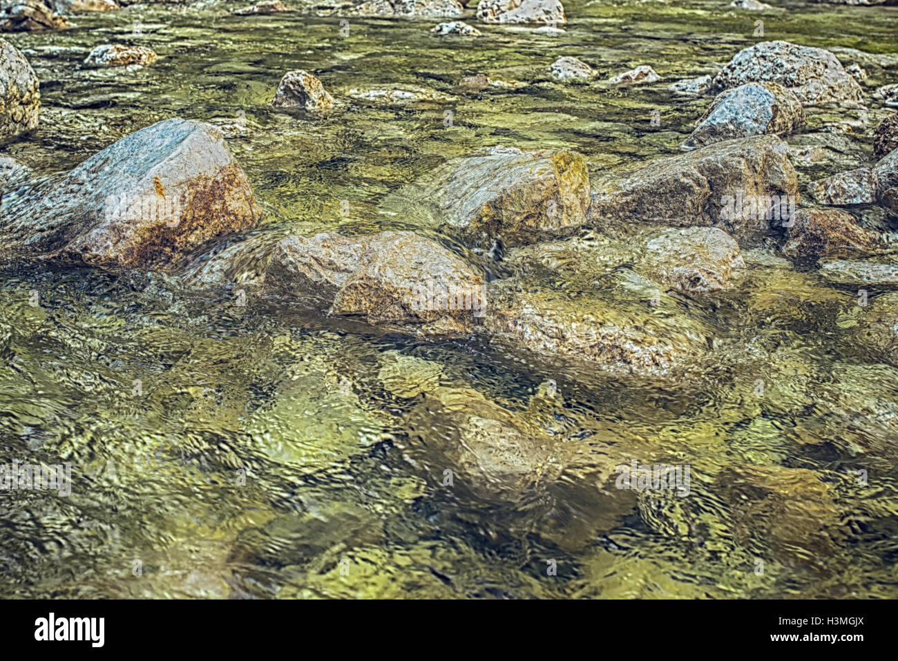 Mountain stream detail, cold freshwater running over rocks and stones ...