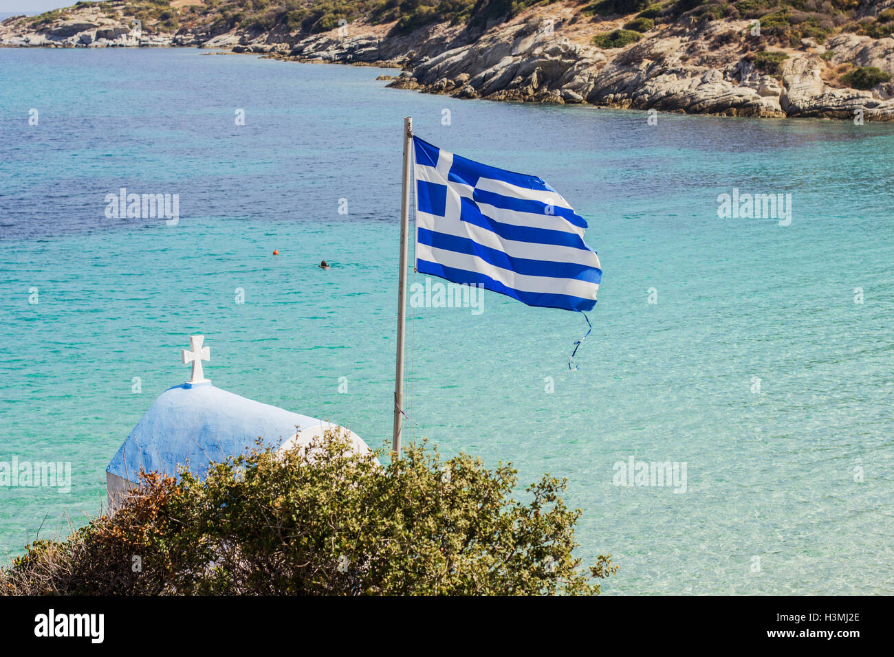 The Greek National Flag over seascape, beautiful turquoise sea , summer ...