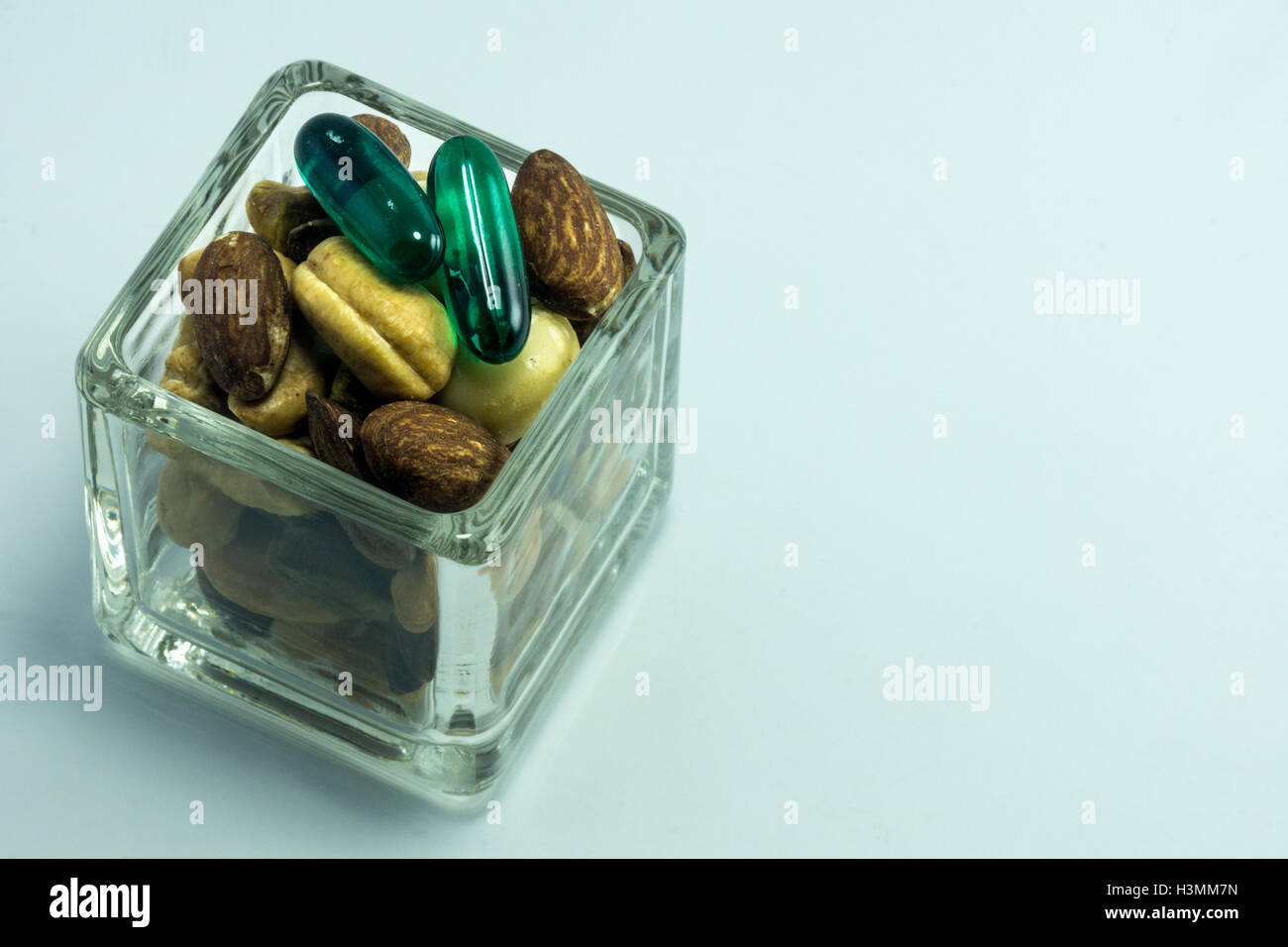 2 capsules on top of mixed nuts in a glass container Stock Photo - Alamy