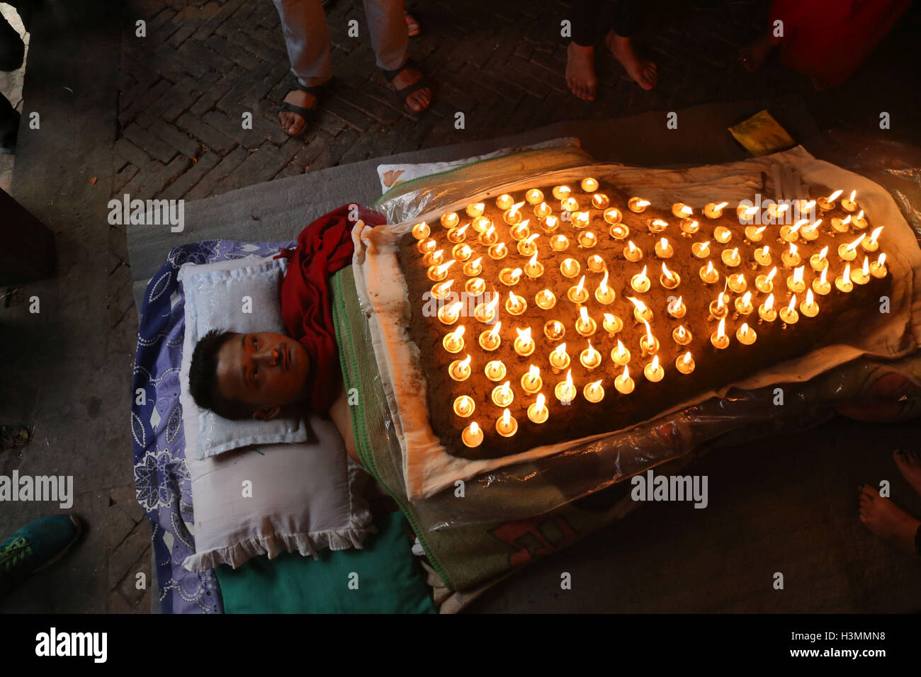 A devotee is seen with lighted oil lamps while offering prayers during ...