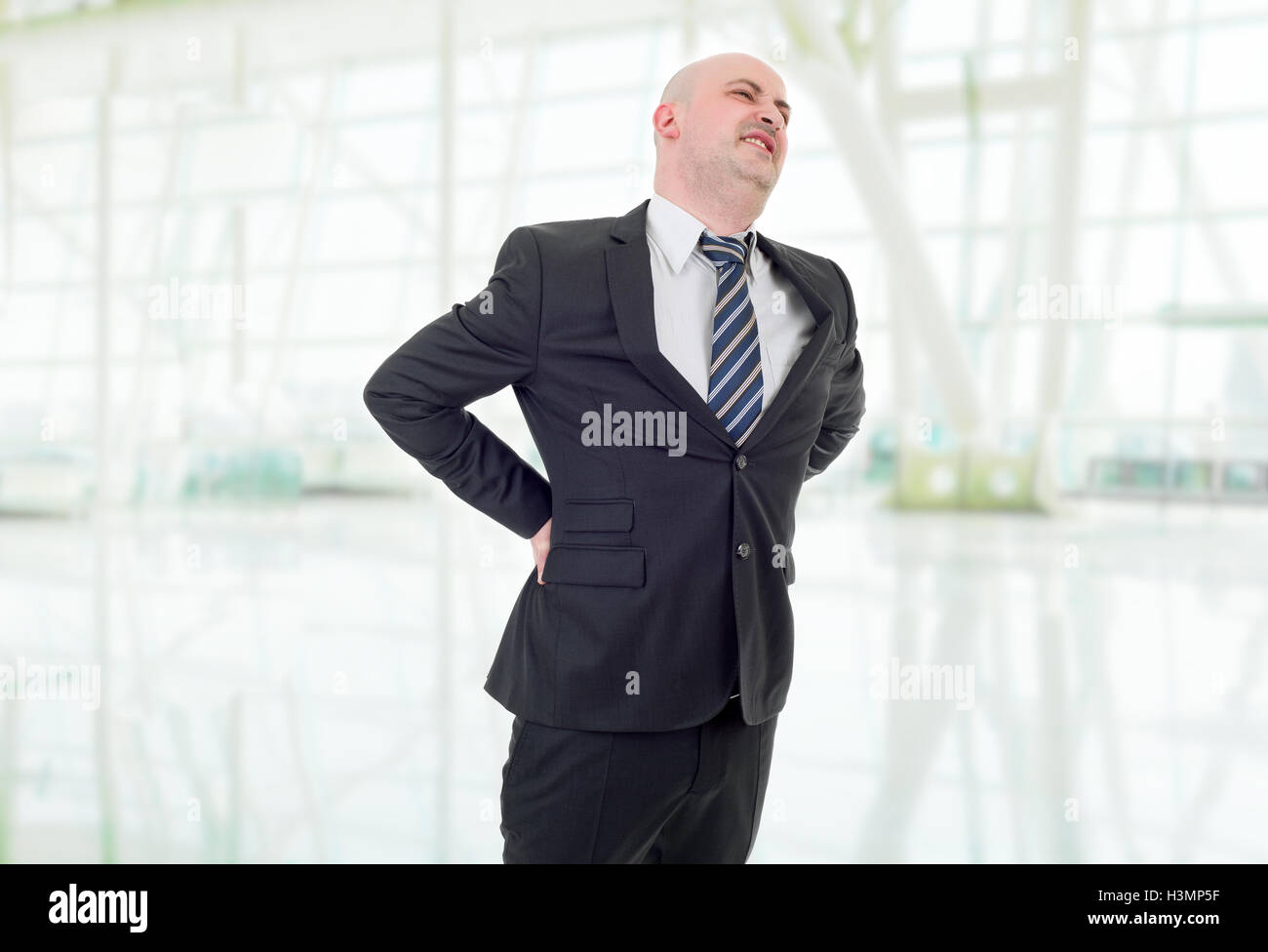 Young businessman with strong back pain, at the office Stock Photo - Alamy