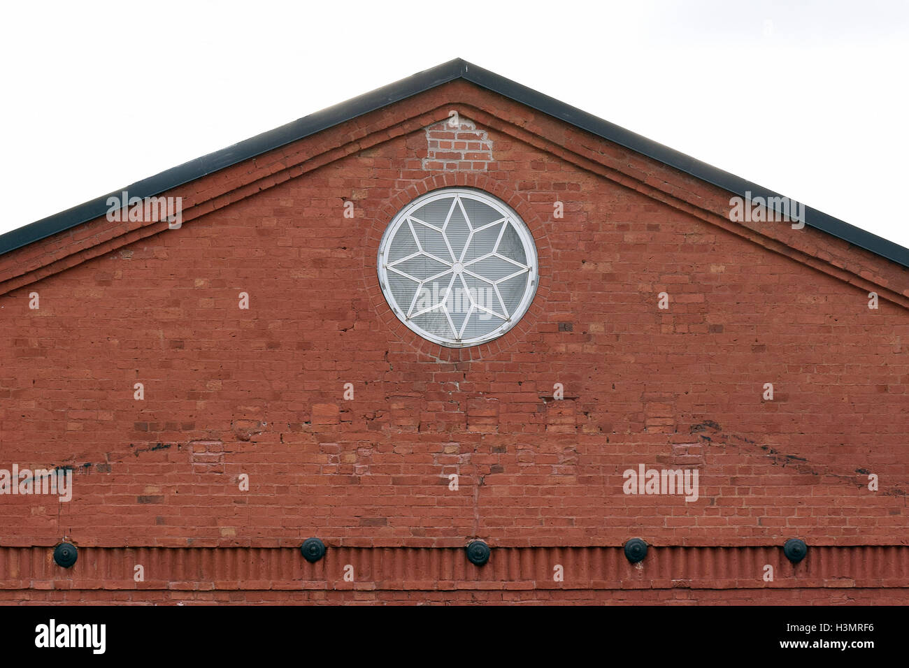 Crest of an old building with round window. Building made of bricks ...