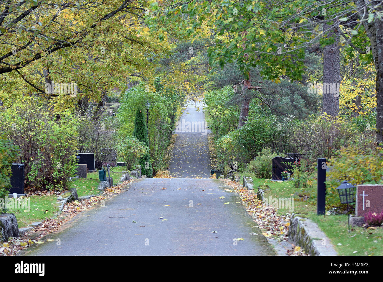 Downhill. Gravestones on both sides of walkway Stock Photo - Alamy
