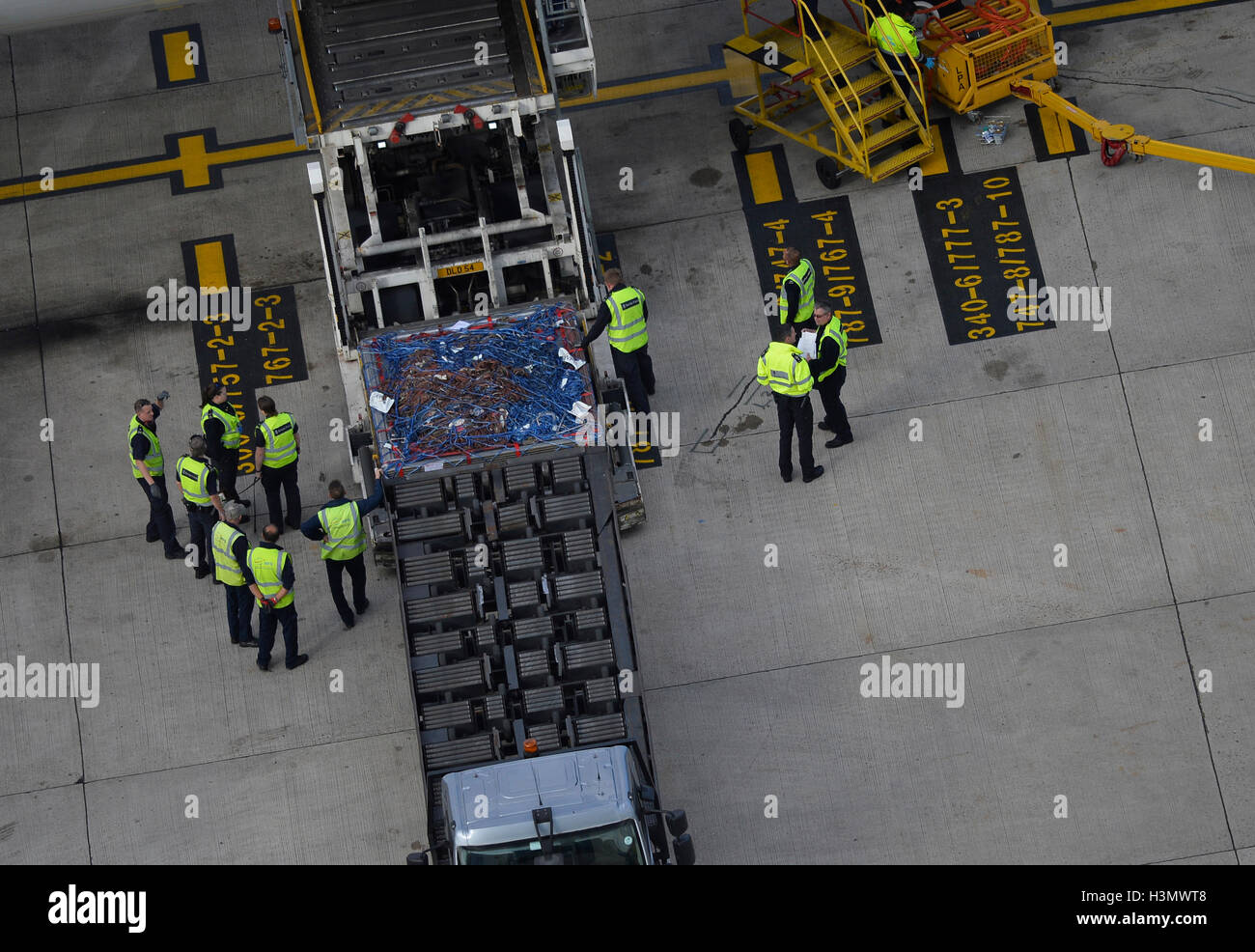 Ground staff work on the runway at London's Heathrow Airport Stock ...