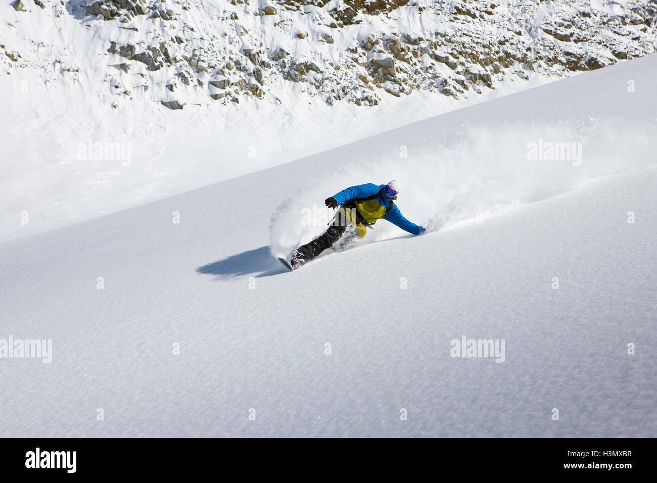 Male snowboarder snowboarding down steep mountain, Trient, Swiss Alps ...
