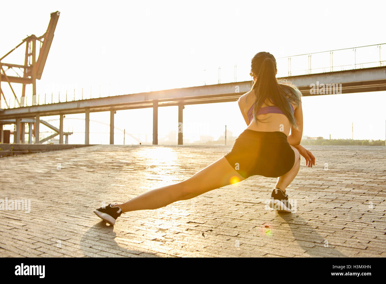 Rear view of woman lunging Stock Photo - Alamy