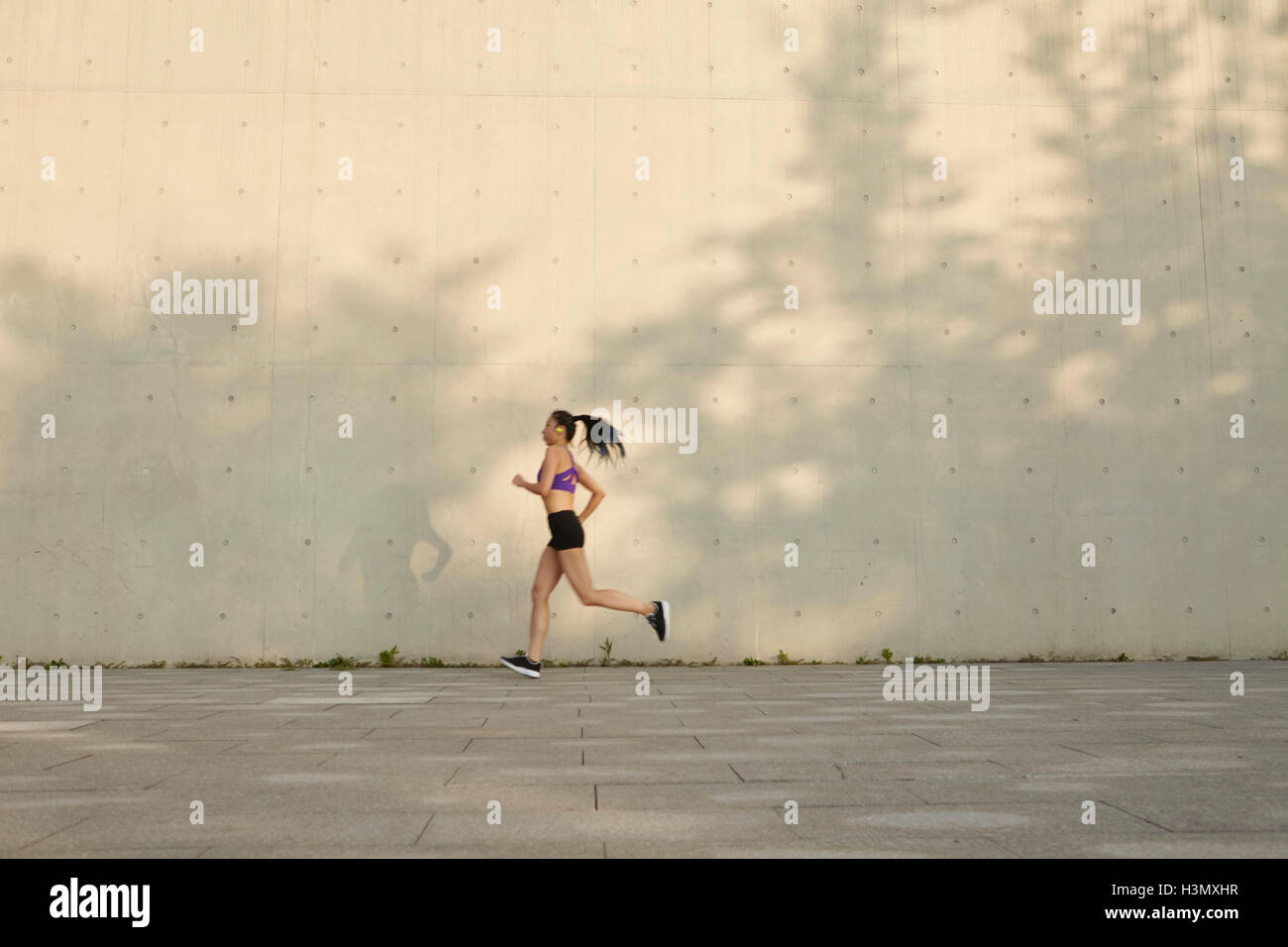 Side view of woman jogging Stock Photo - Alamy