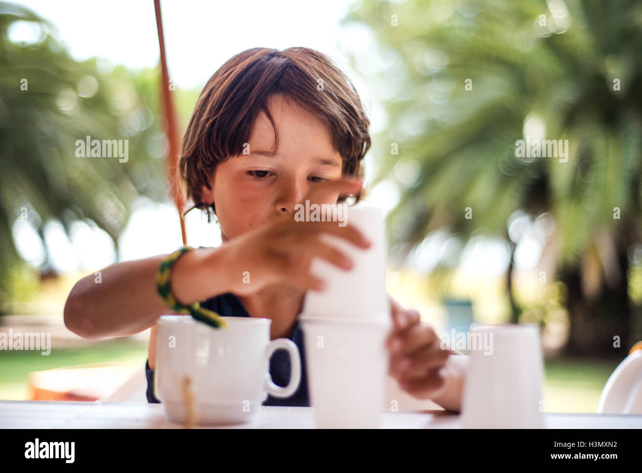 Boy balancing plastic cups Stock Photo - Alamy