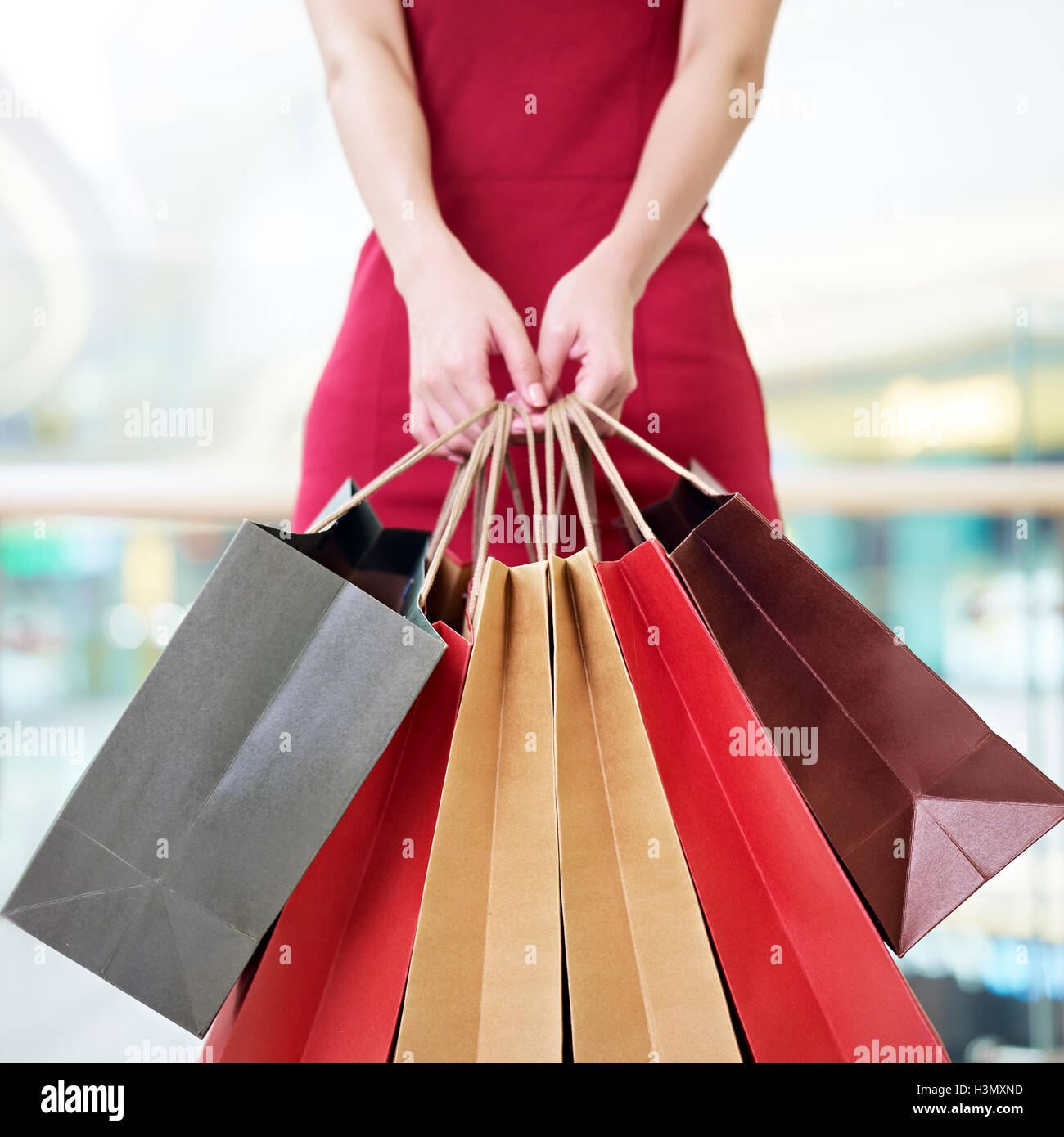 young woman female shopper standing with colorful paper bags in hands ...