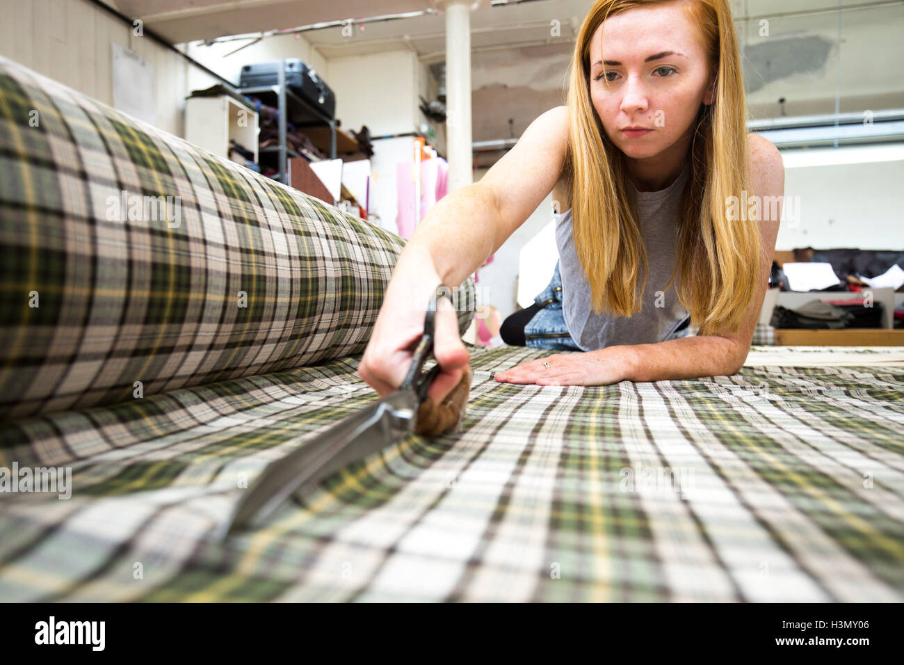 Young woman cutting fabric in leather jacket manufacturers Stock Photo ...