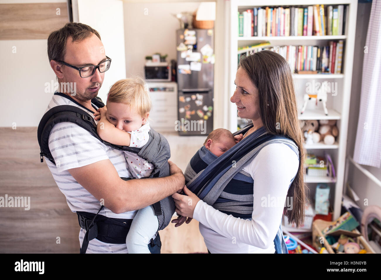 Young parents with children in sling and baby carrier Stock Photo - Alamy