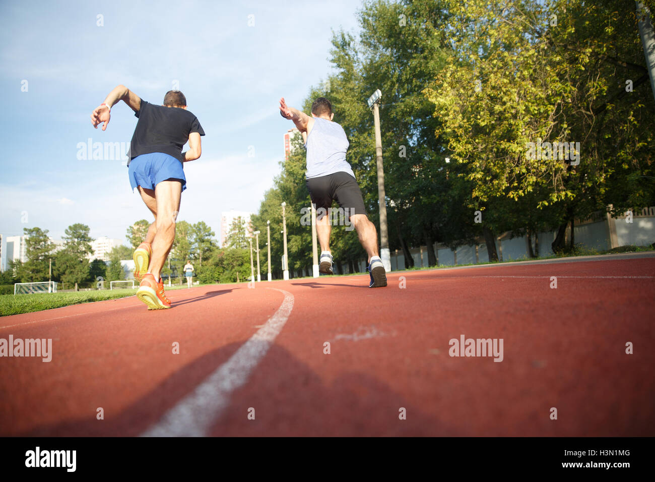 Portrait of two sportsmen competing on running track in park Stock ...