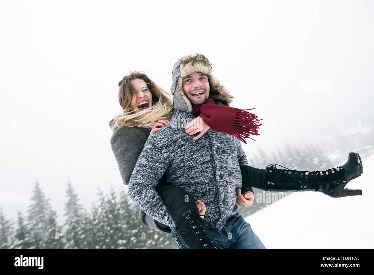 Couple in love, man giving woman piggyback. Winter nature Stock Photo ...