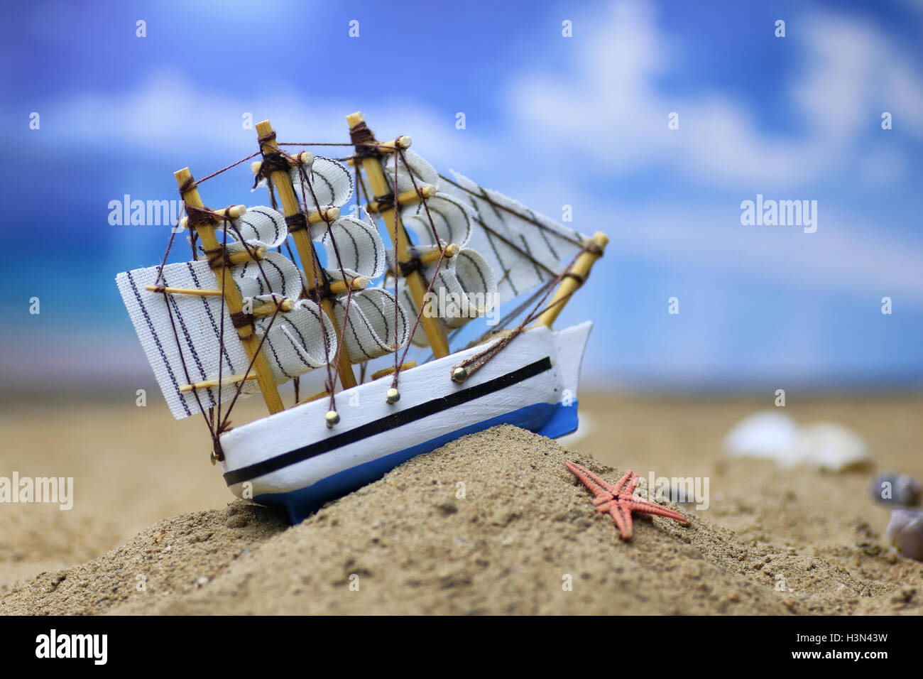 sand shell and sail in sea background travel Stock Photo - Alamy