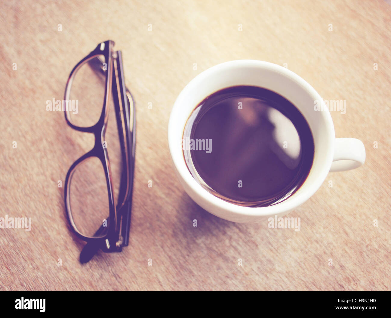 Hot coffee and eyeglasses with retro filter effect Stock Photo - Alamy