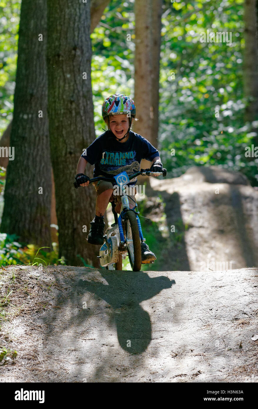 A young (4 year old) boy riding his bike in the wood on a mountain bike pump track Stock Photo ...