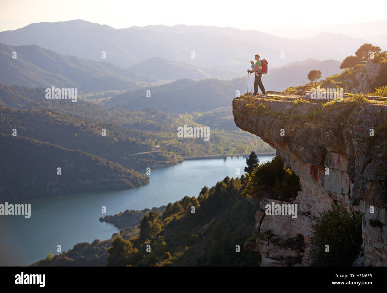 Hiker with baby relaxing on cliff Stock Photo - Alamy