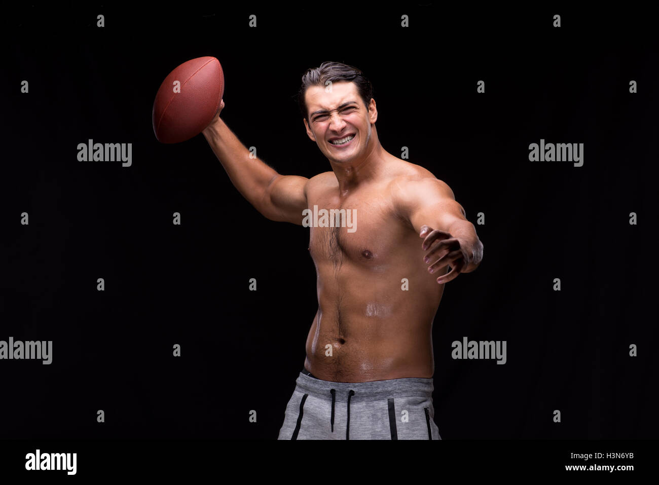 Ripped muscular man with american football Stock Photo - Alamy