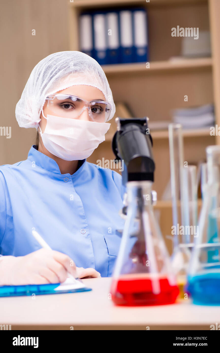 Lab chemist working with microscope and tubes Stock Photo - Alamy