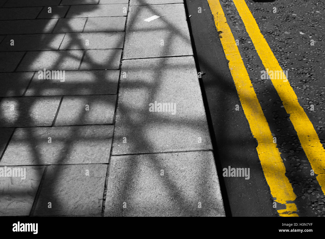 Double yellow lines on a shadowy street Stock Photo - Alamy
