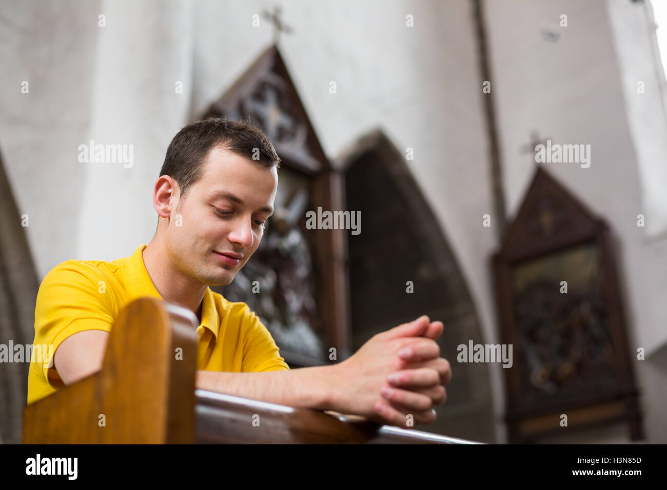 Handsome young man praying in a church Stock Photo - Alamy