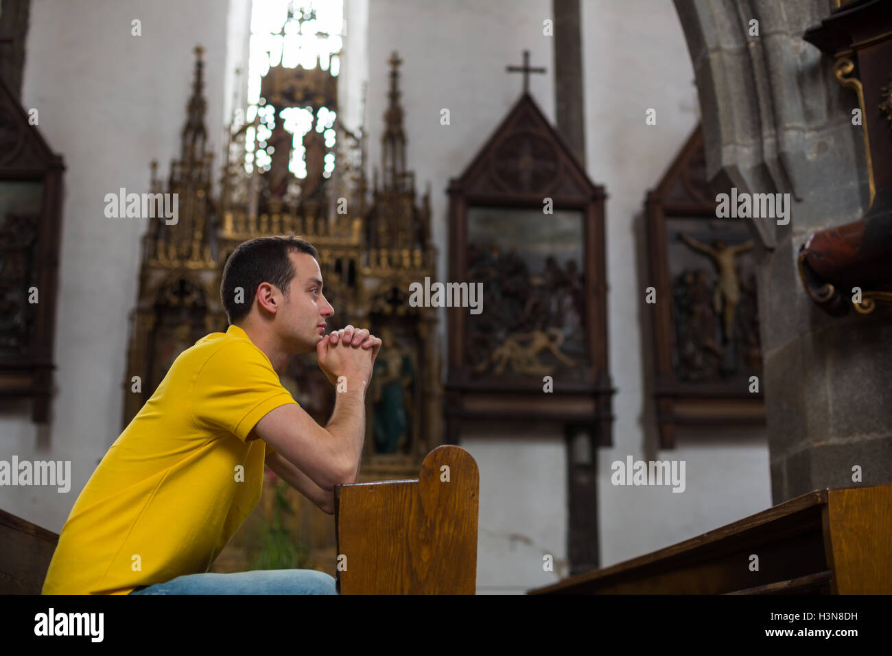 Handsome young man praying in a church Stock Photo - Alamy