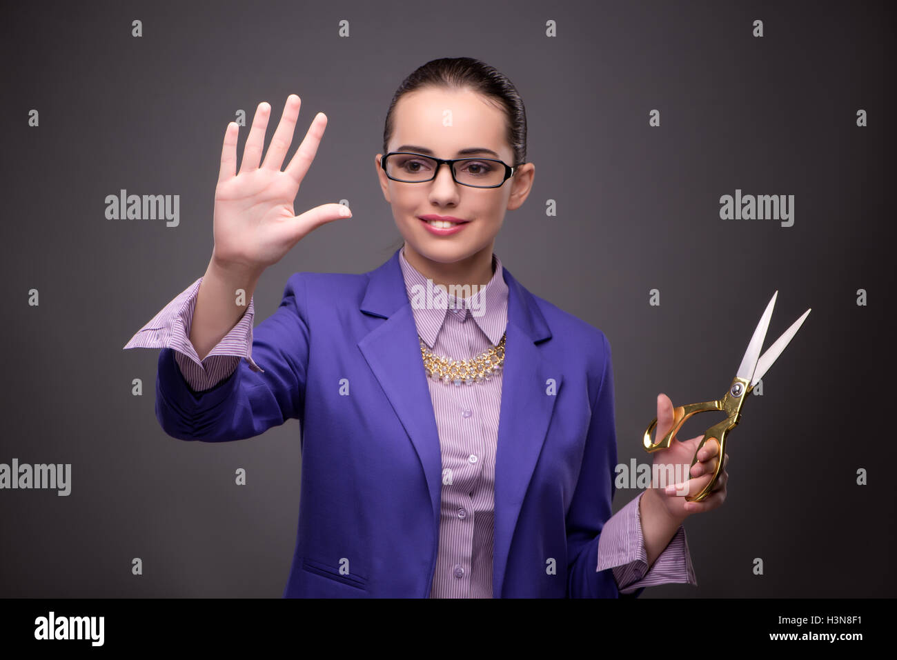 Young woman with scissors against gray background Stock Photo - Alamy