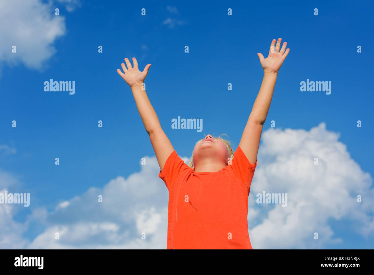 Young boy outdoors, reaching up towards sky Stock Photo - Alamy