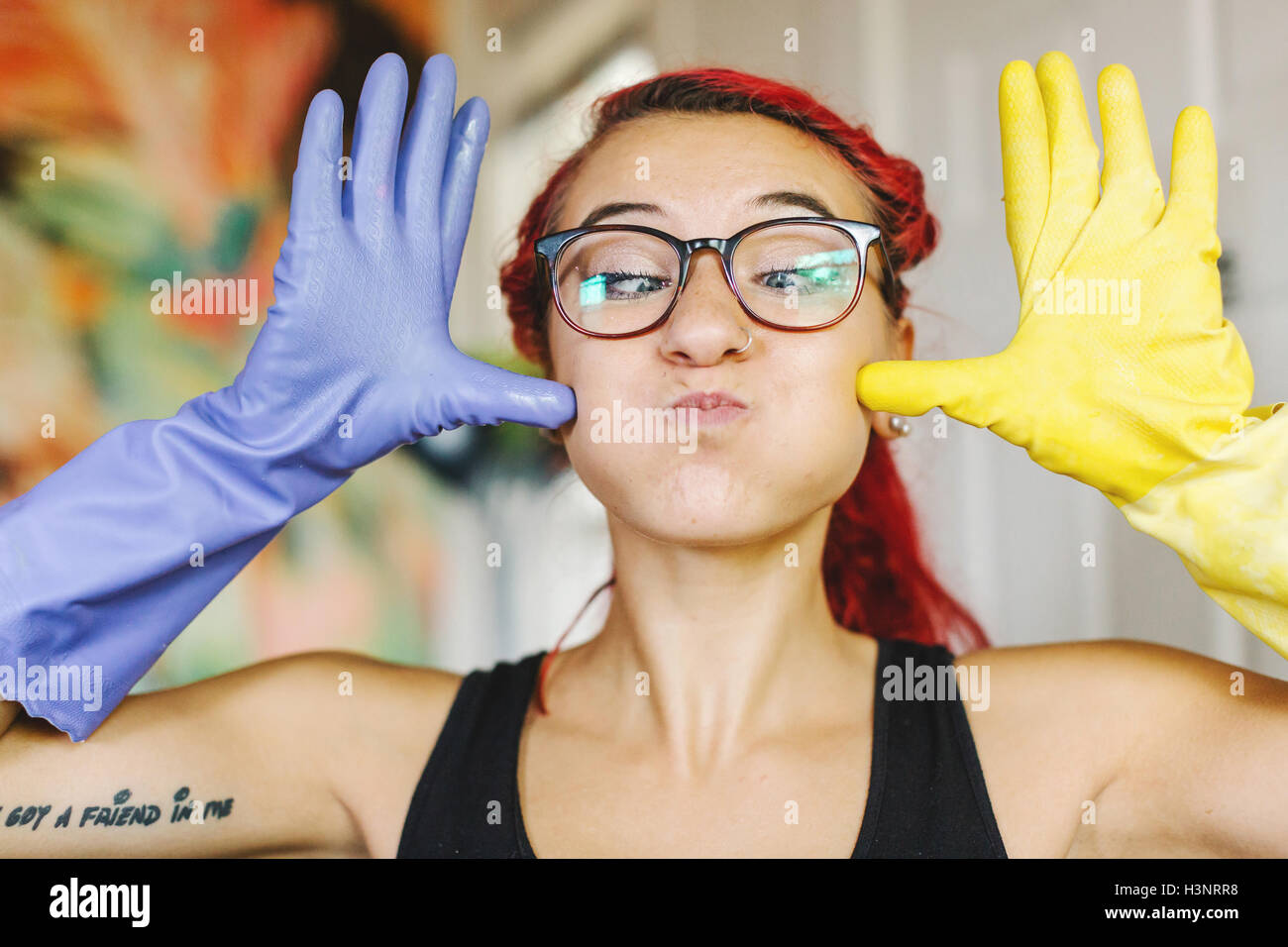 Portrait of young woman with pink hair pulling a face wearing ...