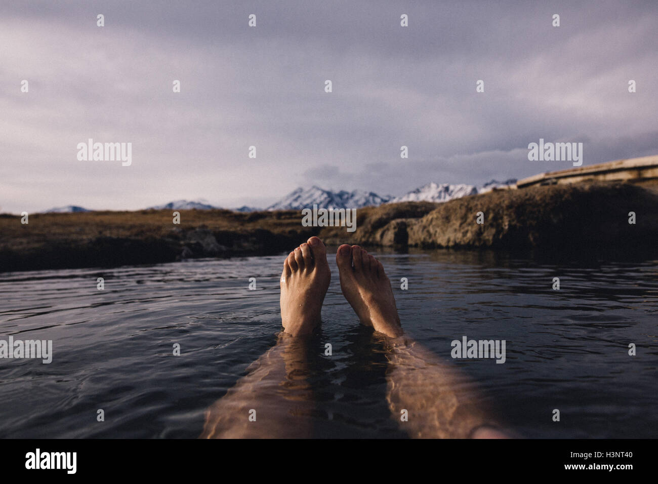 Legs of man floating in water on lake, Mammoth Lakes, California, USA ...