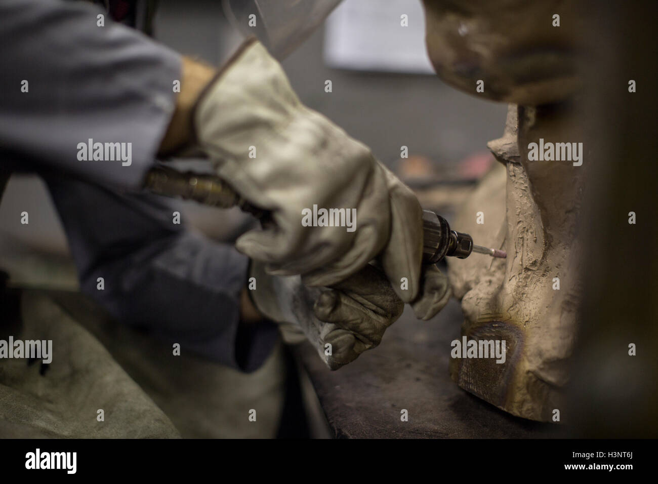 Sculptor in artists' studio creating sculpture using hand tool Stock ...