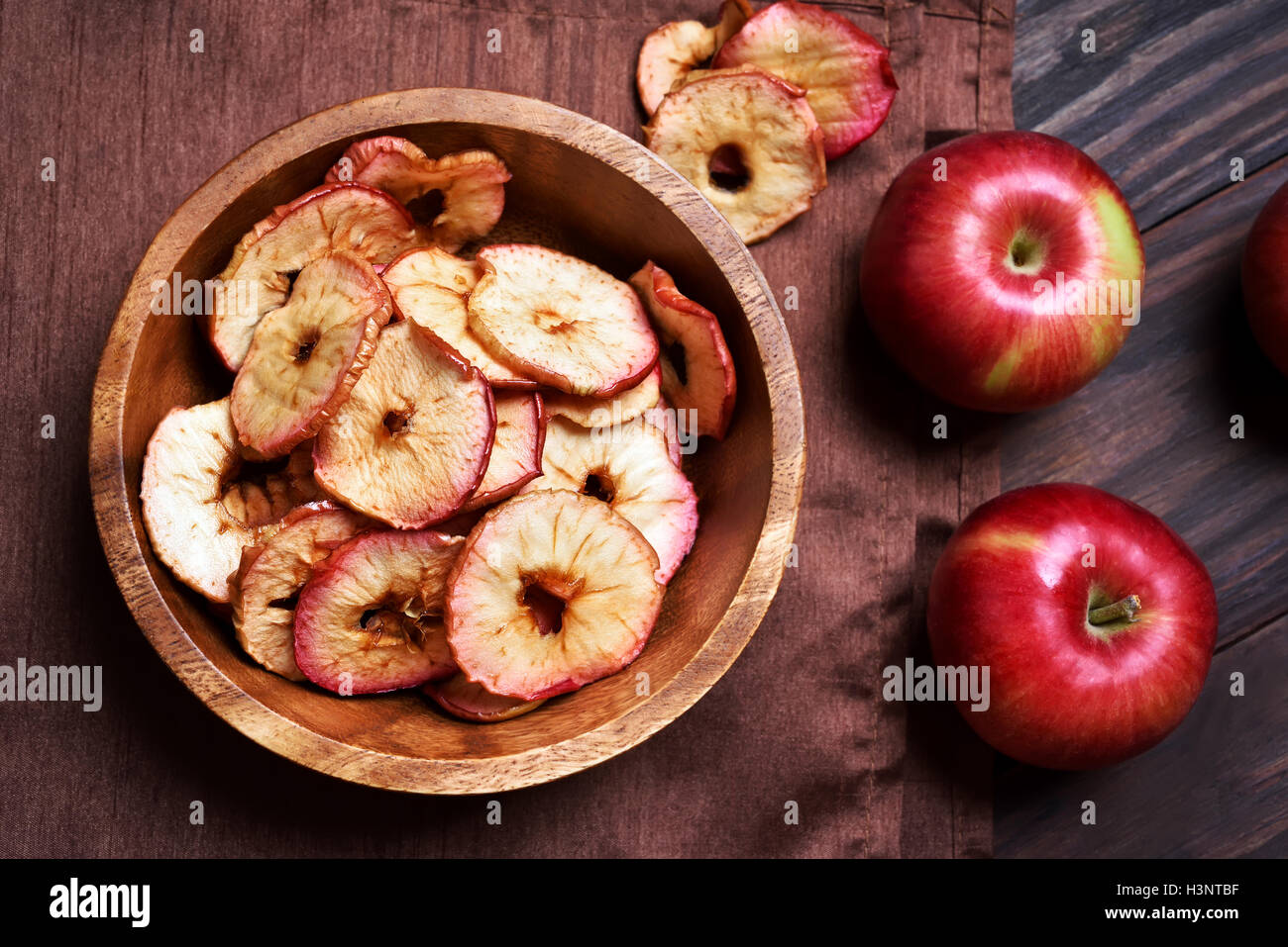 Dehydrated apples chips in wooden bowl, top view Stock Photo - Alamy