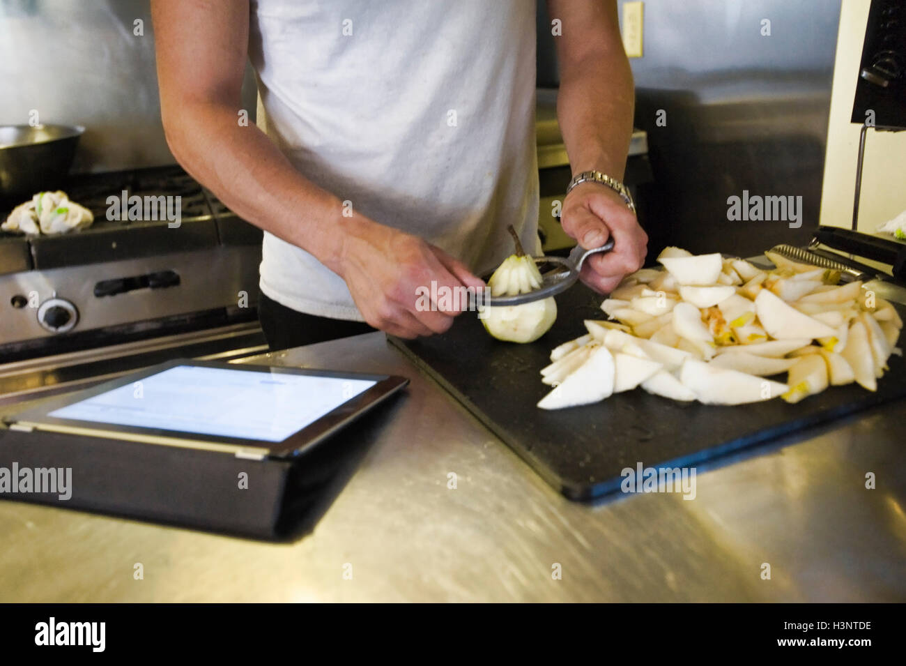 Chef cutting pear in kitchen Stock Photo - Alamy